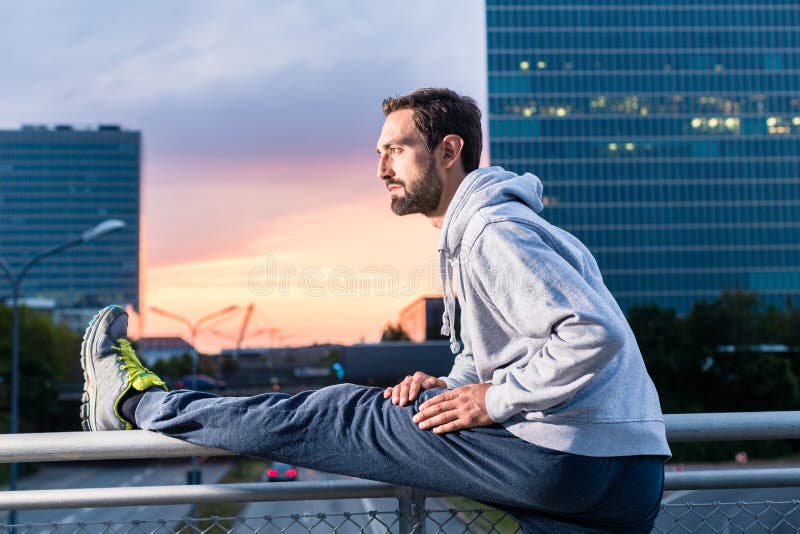 Runner Stretching in Front of Office Building at Sunset Stock Image ...