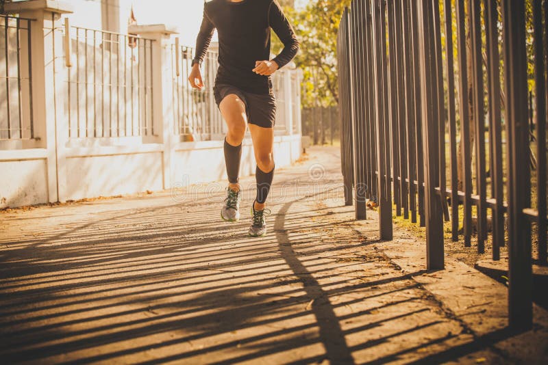 Runner Su Strada Al Tramonto Immagine Stock - Immagine di atletico ...
