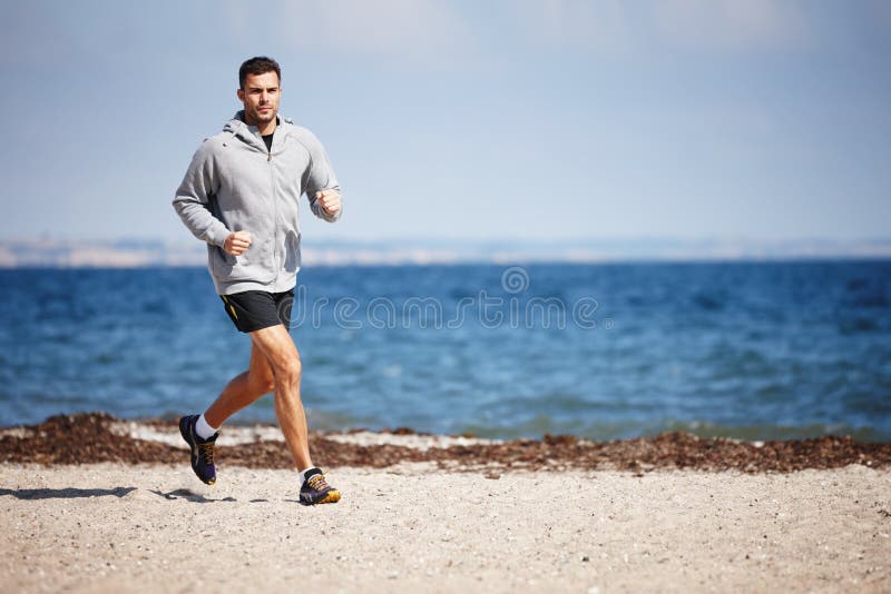 Running on the Beach. a Handsome Young Man Running on the Beach. Stock ...
