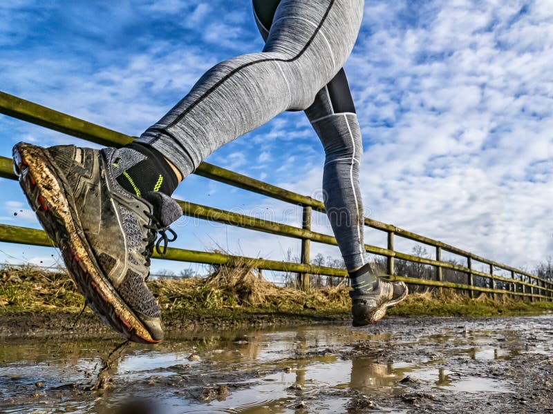 Running on a muddy trail stock image. Image of legs - 245052533