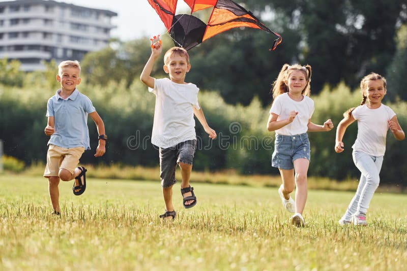 Running Together. Group of Kids are Running and Playing with Kite on ...