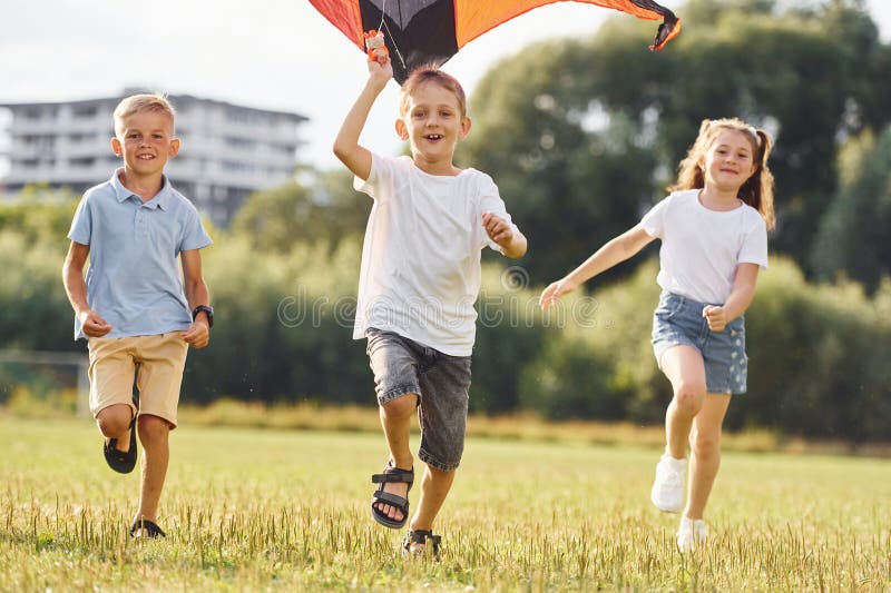 Running Together. Group of Kids are Running and Playing with Kite on ...