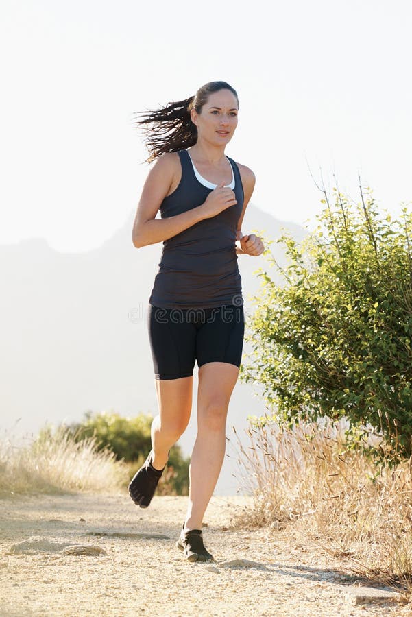 Running is a Way of Life. a Young Woman Running Along a Trail. Stock ...
