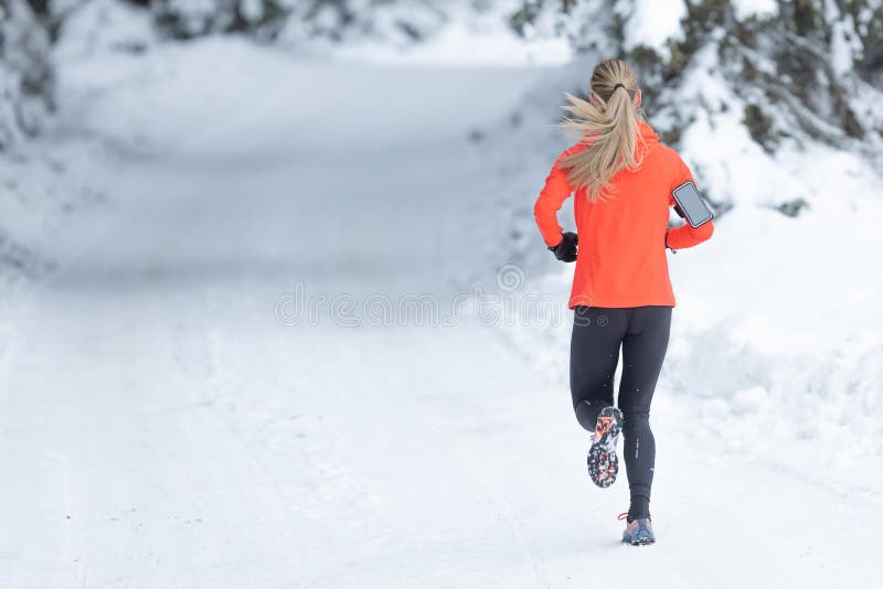 Running in Winter, Rear View of a Female Runner on a Snowy Path in a ...