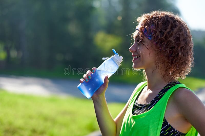 Running Woman is Having Break, Drinking Water during Run in Summer Park ...