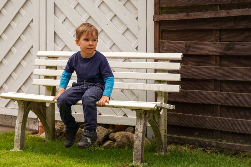 Rural Child Sitting Alone on a Bench in the Park. Stock Image - Image ...