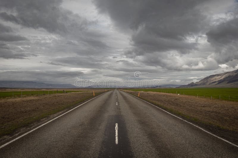 Road Stretching through a Rolling Landscape of Grassy Fields Beneath a ...