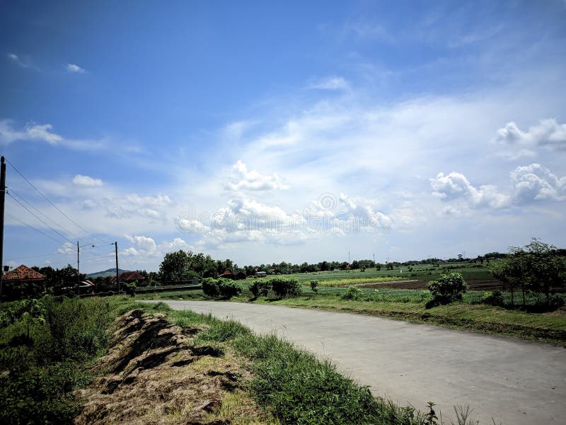 Rural Road Under Blue Sky with Clouds Stock Photo - Image of rural ...