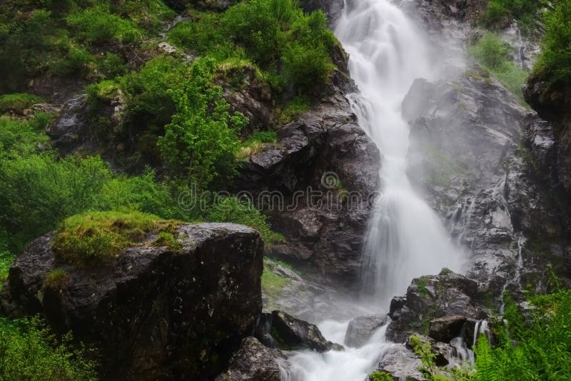 Rushing Large Waterfall Over Rocks with Green Plants on the Side Stock ...
