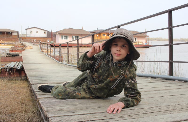 Russia, a Boy is Resting on a Pier by the Tourist River on a Bridge ... Russia, a Boy is Resting on a Pier by the Tourist River on a Bridge ...