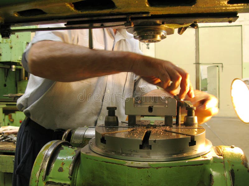 An Elderly Worker Works on a Milling Machine in a Machine Shop during ...