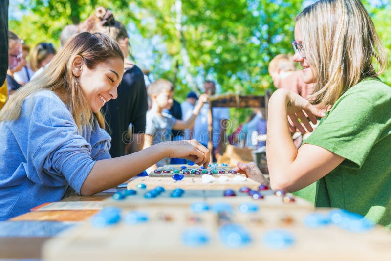 A Group of Children Playing the Board Logic Game `the Mill` in the Park ...
