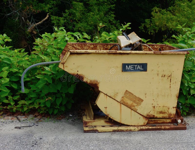Rusted Bright Yellow Metal Container Bin on Grey Pavement with Greenery ...