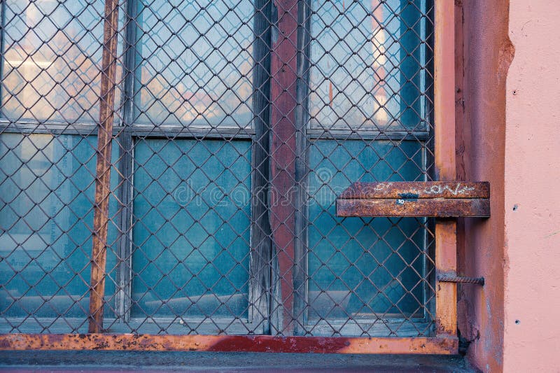 Rusted Metal Grid Guards a Glass Window in an Old, Decaying Structure ...