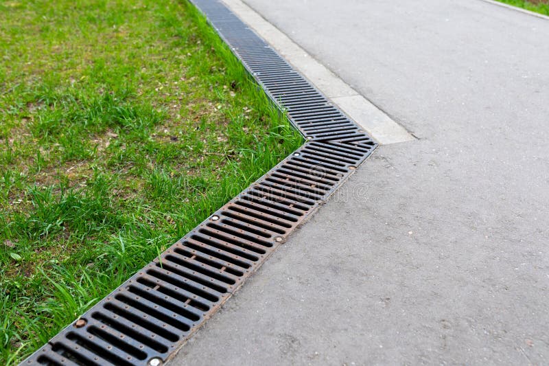 Rusted Metal Sewer Grate Along Paved Walkway. Edge of Pavement Stock ...