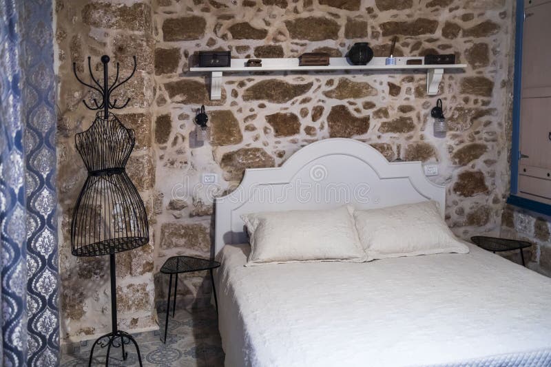 Rustic Bedroom with a White Bed, Stone Walls, Stock Image - Image of ...