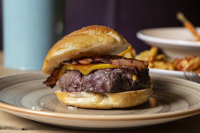 Rustic Beef Burger with Cheese and Bacon Served on a Plate Stock Image ...