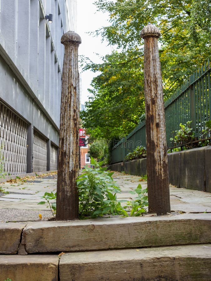 Rustic Bollards Flanking a Leafy Stone Path in an Urban Setting Stock ...