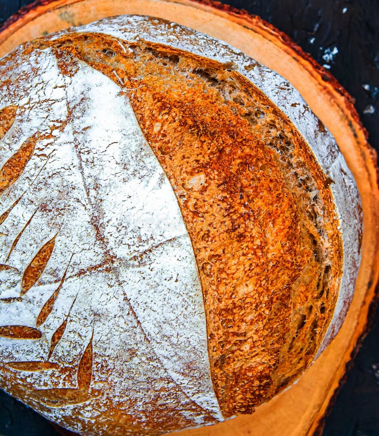 Rustic Bread with Seeds on a Wooden Table in Flour, Black Background ...