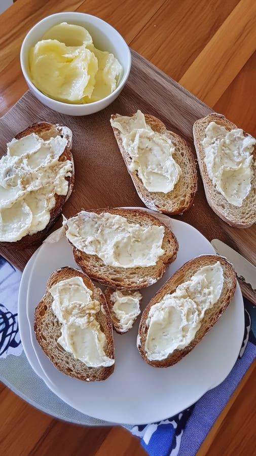 Rustic Breakfast with Buttered Bread and Creamy Spread on Cutting Board ...