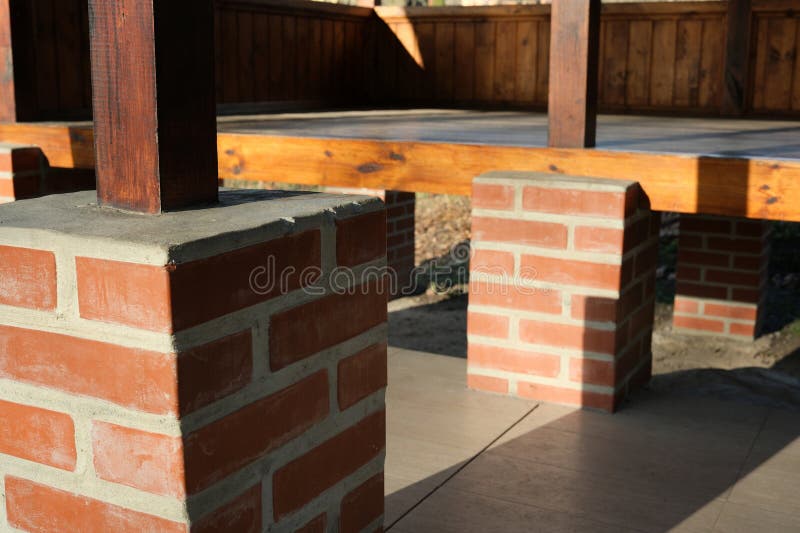 Rustic Brick Pillars Support a Charming Wooden Structure in Sunlight ...