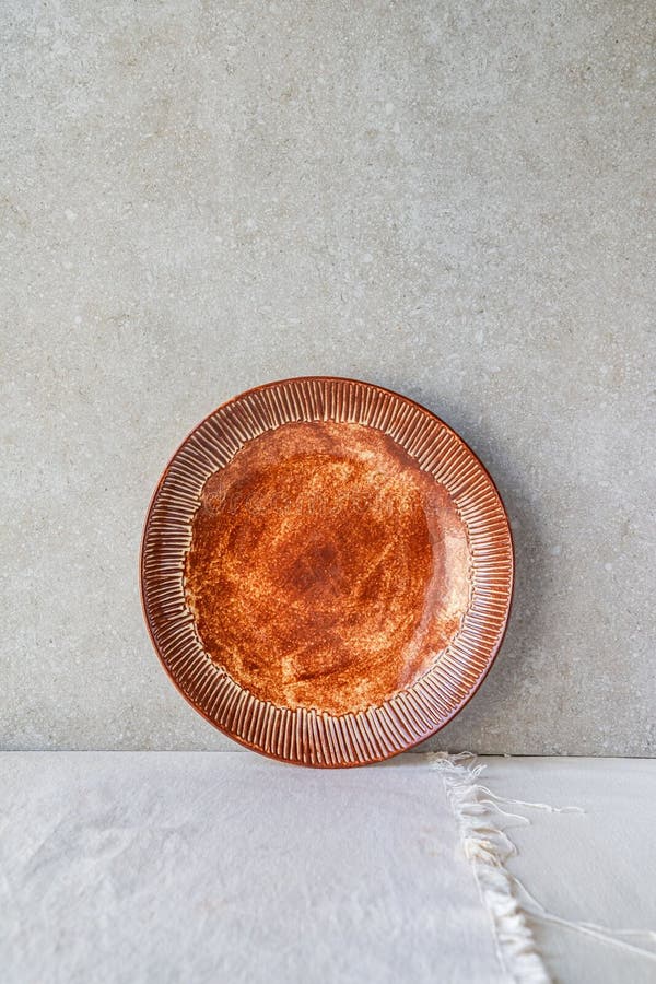 Rustic Brown Ceramic Plate on a Textured Surface with a White Cloth ...