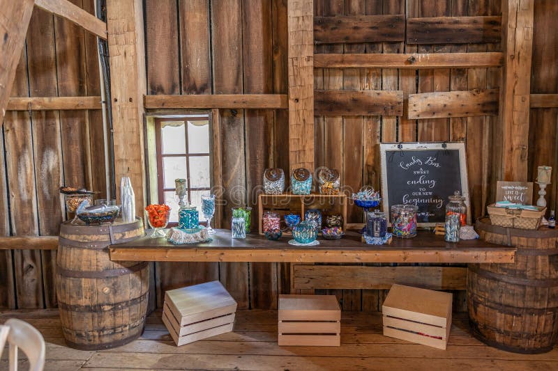 Rustic Candy Bar Setup in a Wooden Barn with Various Sweets in Glass ...