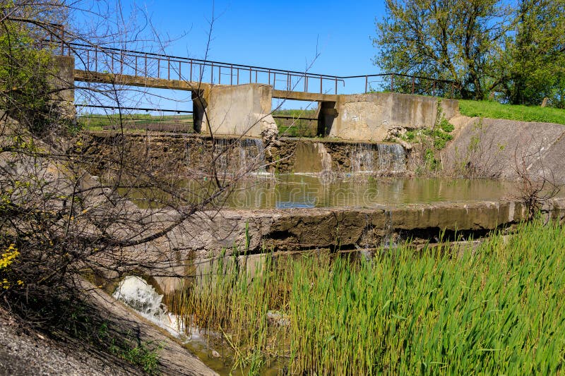 Rustic Concrete Bridge Over Serene Waterfall in Lush Green Landscape ...