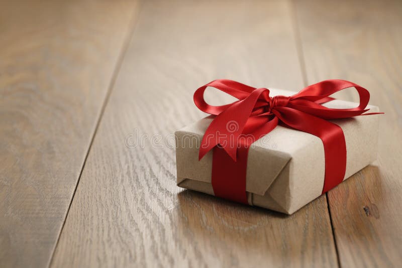 Rustic Craft Paper Gift Box with Red Ribbon Bow on Wood Table Stock ...