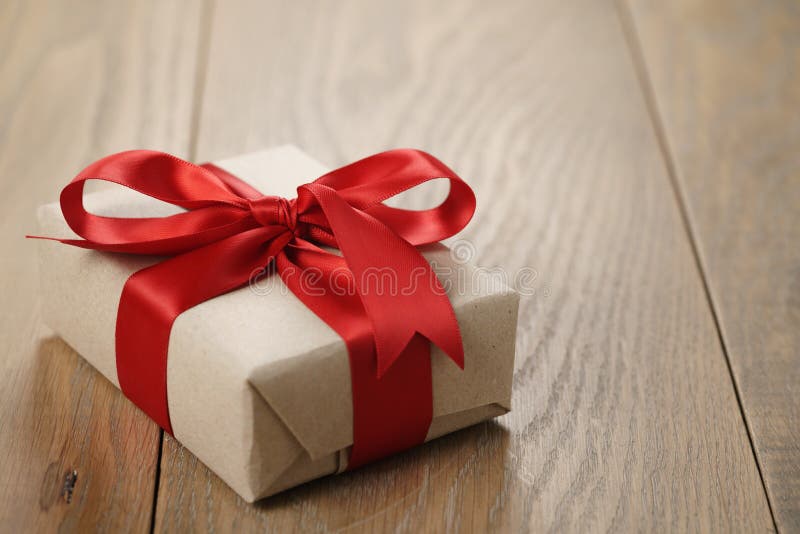 Rustic Craft Paper Gift Box with Red Ribbon Bow on Wood Table Stock ...