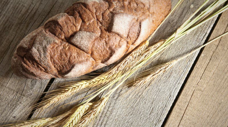 Rustic Crusty Bread and Wheat Ears on a Dark Wooden Table Stock Photo ...