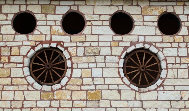 Rustic Feature Stone Wall with Wagon Wheels and Round Portals Inside ...