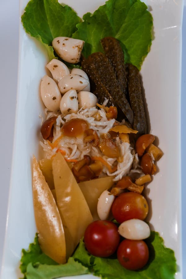 Rustic Gourmet Platter with Marinated Vegetables and Fresh Leaves in ...