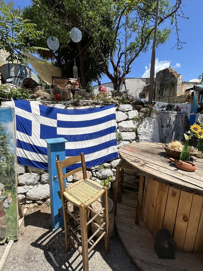 Rustic Greek Bar Corner with Flag and Cable-Wire Table Stock Image ...