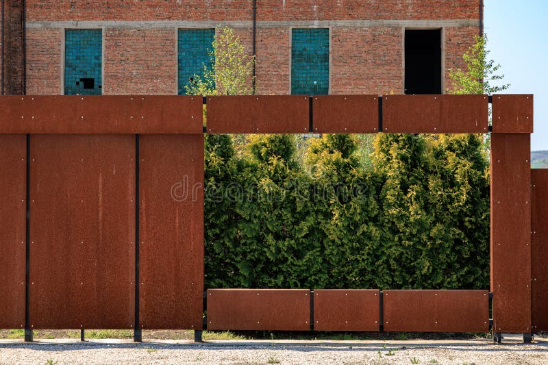 Rustic Industrial Wall with Verdant Foliage and Brick Building in Urban ...