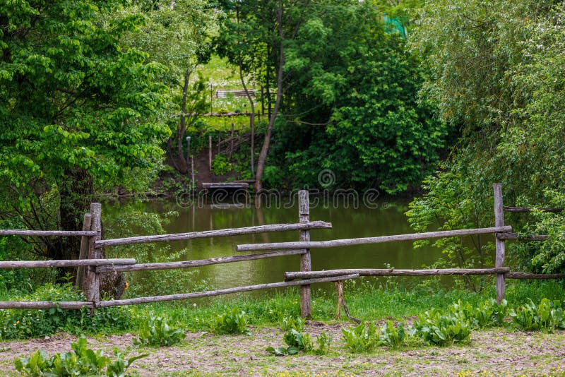 Rustic Log Fence in Front of Pond or River with Small Pier Stock Photo ...