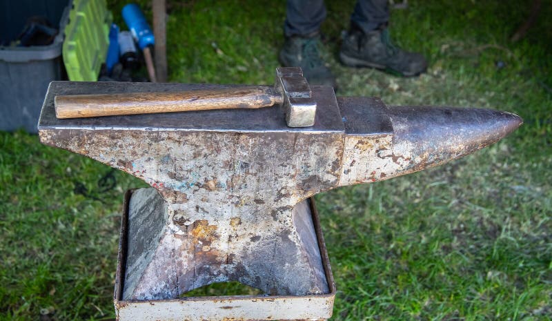 Rustic Metal Anvil and Hammer on Grass, Representing Traditional ...