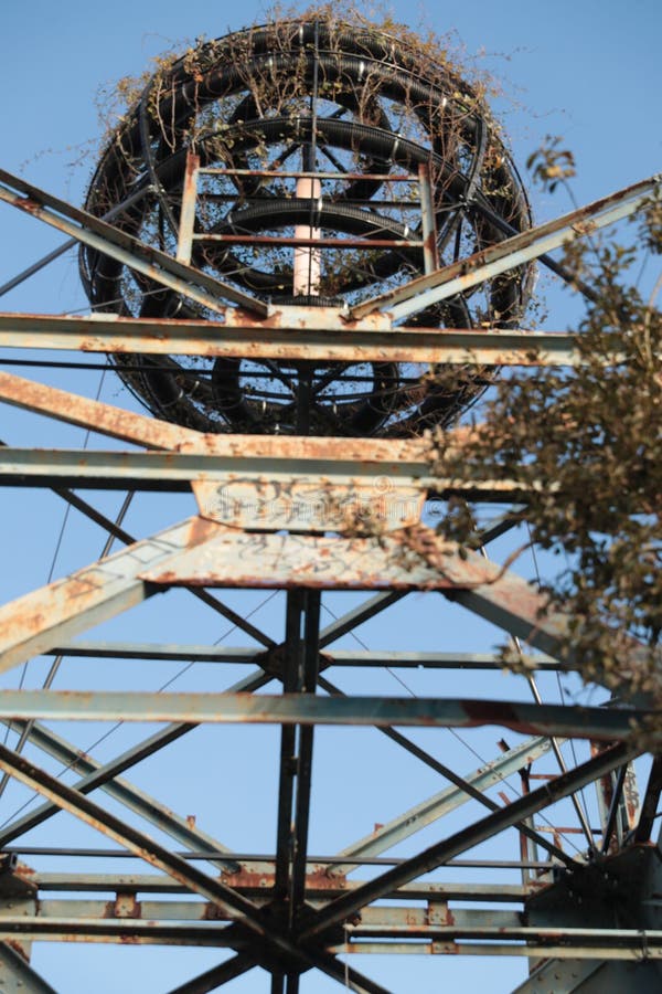 Rustic Metal Framework with Overgrown Circular Element Against Blue Sky ...