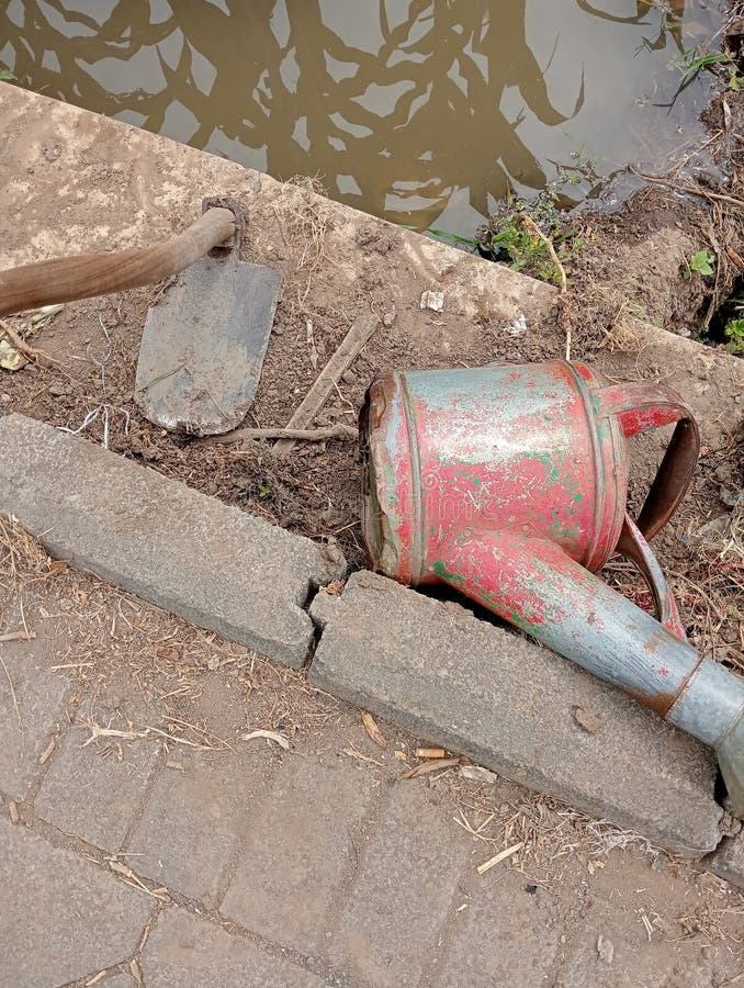 Rustic Metal Watering Can and Hoe on Farm Edge Stock Image - Image of ...