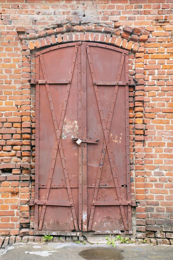 Rustic Red Metal Door with Peeling Paint and a Rusty Lock on a Brick ...