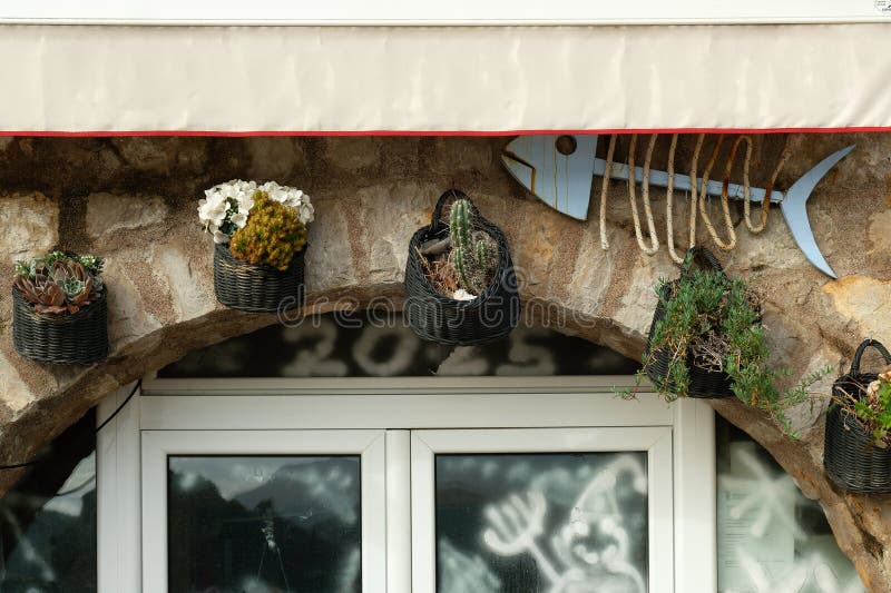 Rustic Shopfront with Plants and Decorative Fish, Folded Awning at a ...