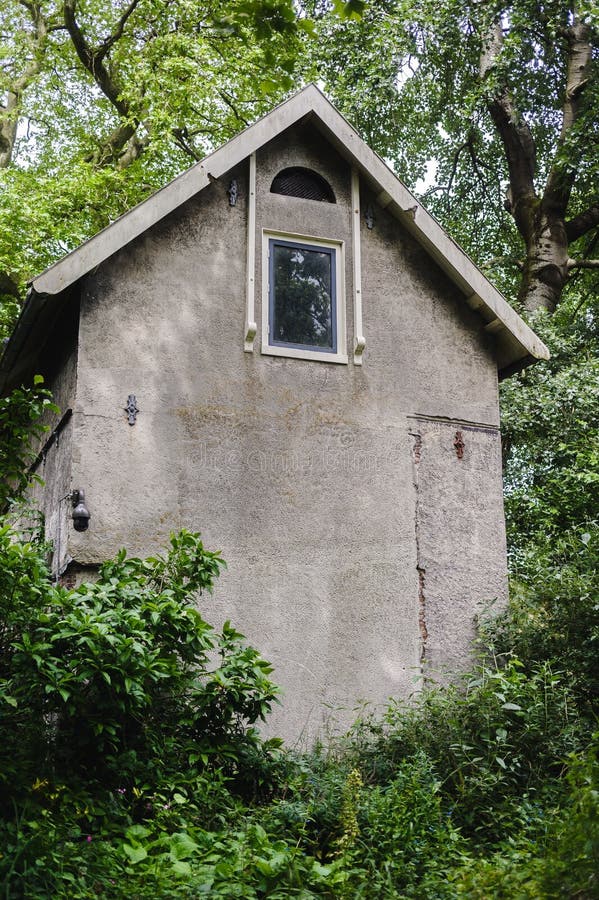 Rustic Small House with a Single Window, Surrounded by Lush Greenery ...