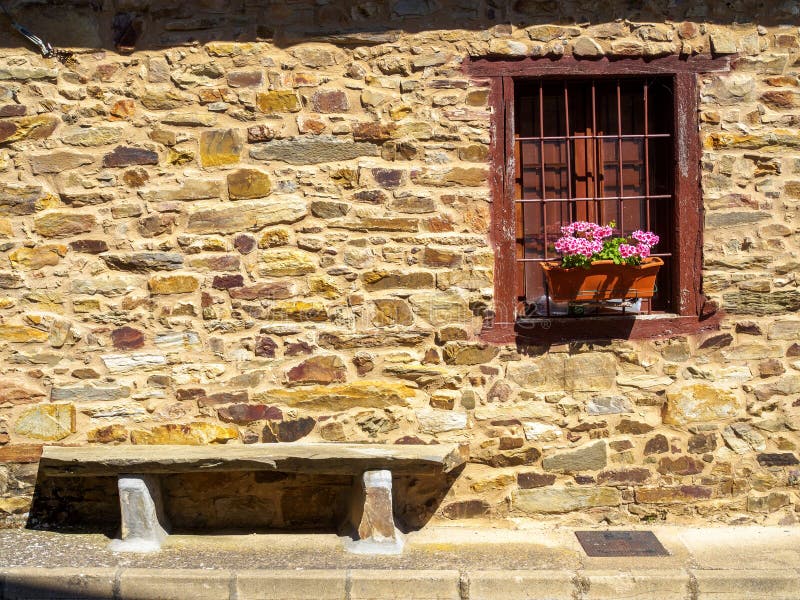 A Rustic Stone Wall Featuring a Window and Stone Bench, in a ...