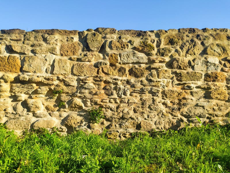 Rustic Stone Wall Texture. Ancient, Weathered Masonry Under a Clear Sky ...