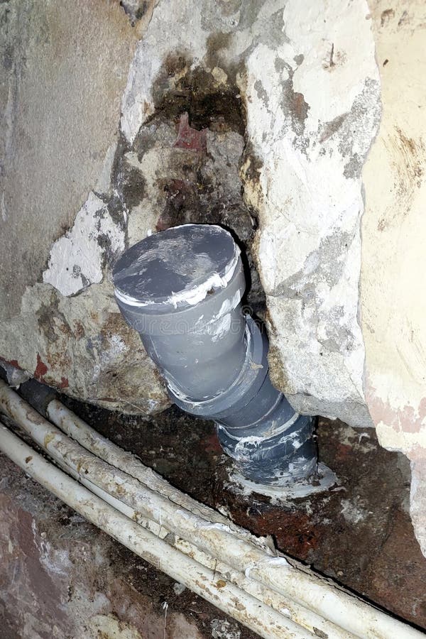 Rustic Wall Showcases a Complex Plumbing System with Ongoing Repair ...