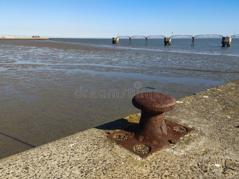 Rustic, Weathered Bollard on a Concrete Pier Overlooking a Tranquil Bay ...