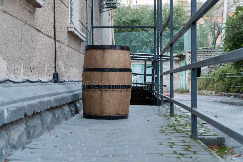 Rustic Wooden Barrel on Cobblestone Pathway by a Building Entrance ...