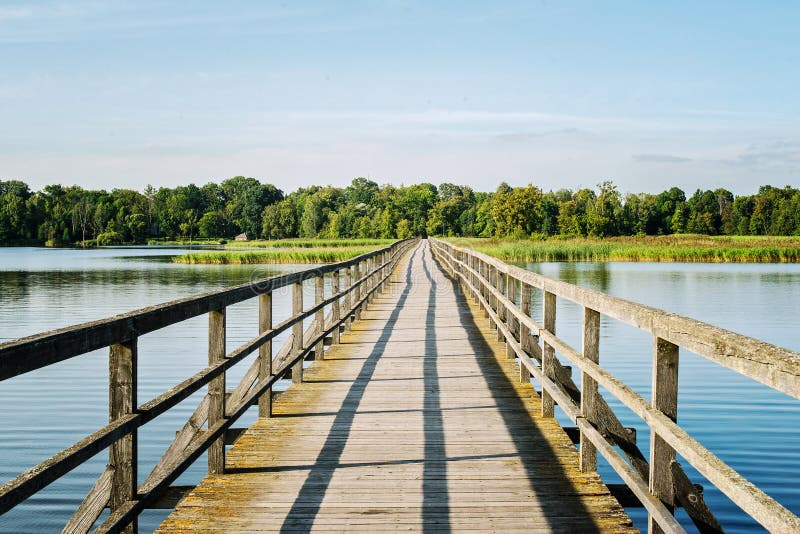 Rustic Wooden Bridge Leading Across a Wide River Stock Image - Image of ...
