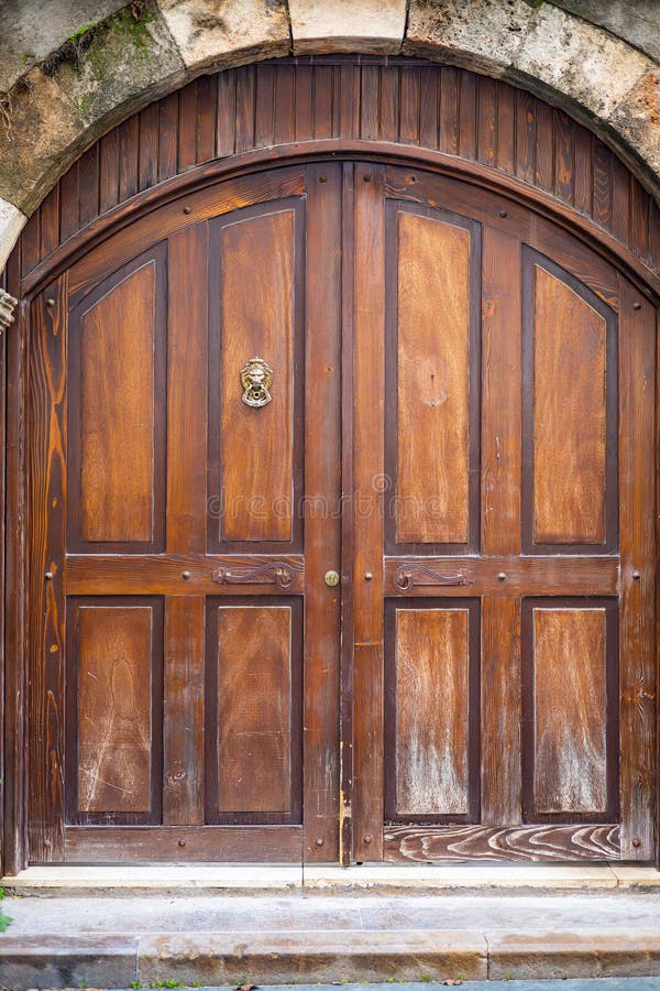 Rustic Wooden Double Door with Arched Design in Stone Wall Setting ...