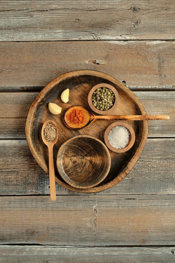 A Rustic Wooden Platter with Various Spices and Herbs on a Wooden Table ...